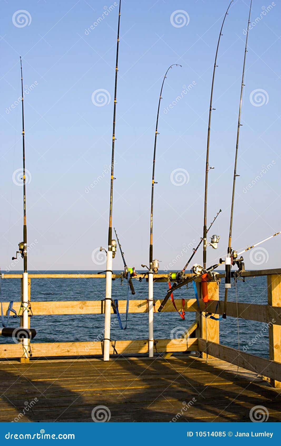 Fishing Poles on Ocean Pier Stock Image - Image of blue, rail: 10514085