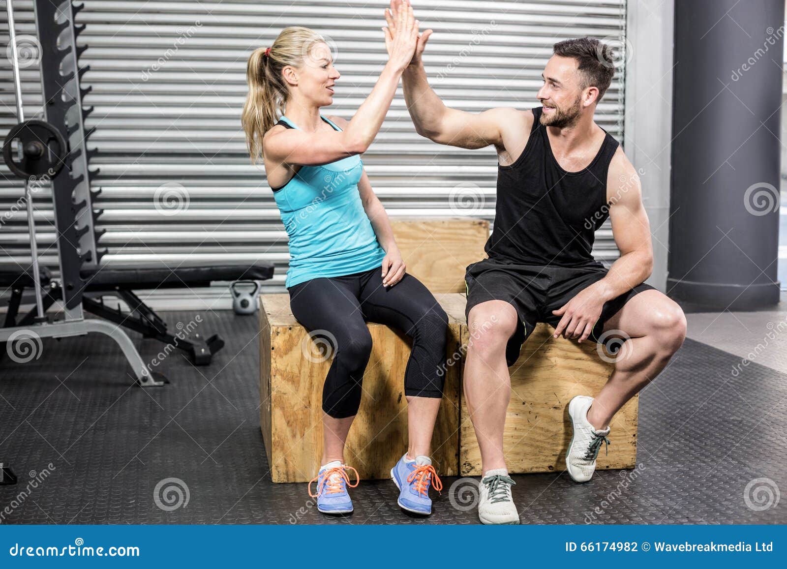 Fit couple doing high five stock photo. Image of indoors - 66174982