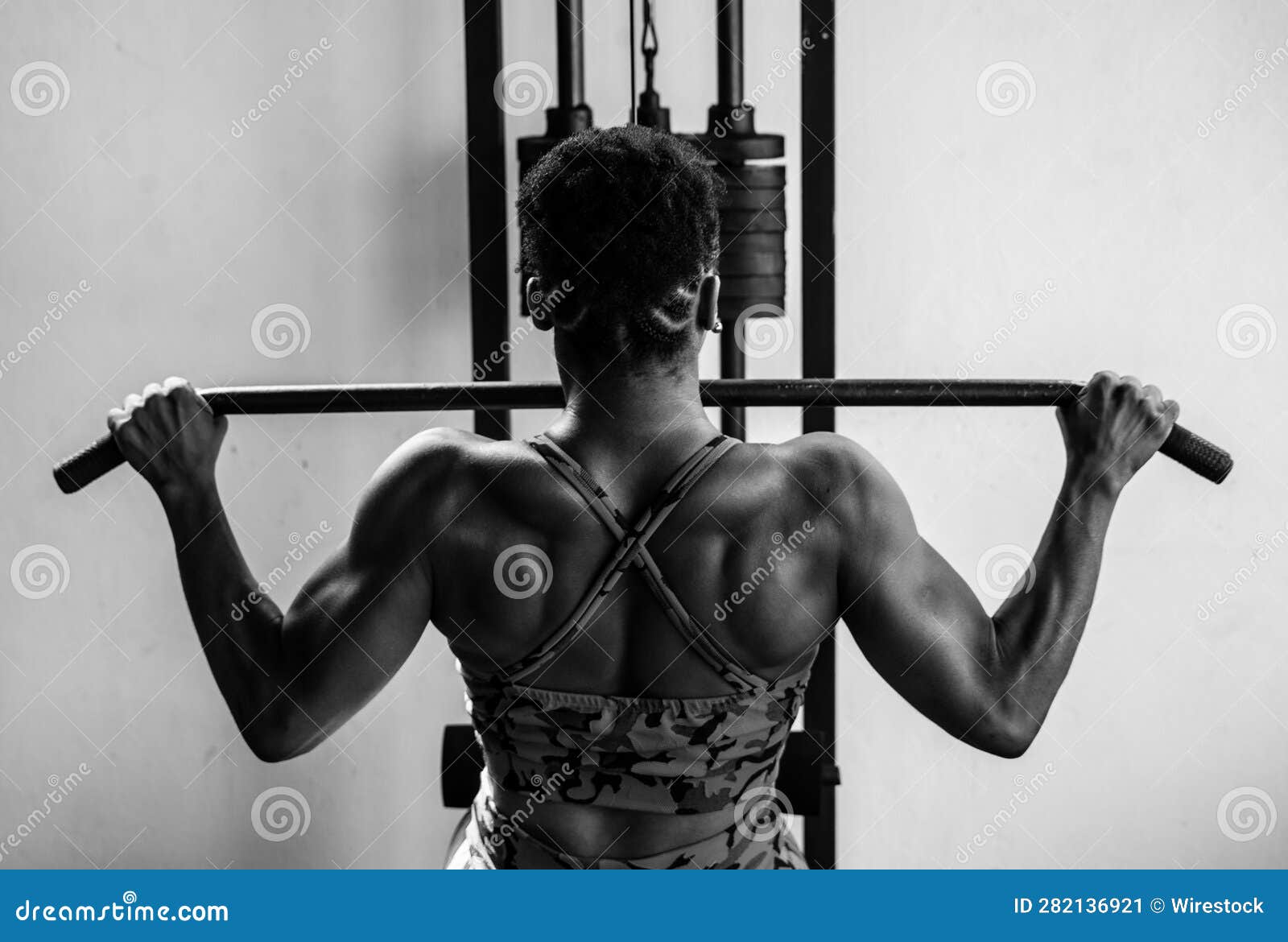 Fit Female is Performing a Pull-down Exercise in a Gym, Her Back and ...