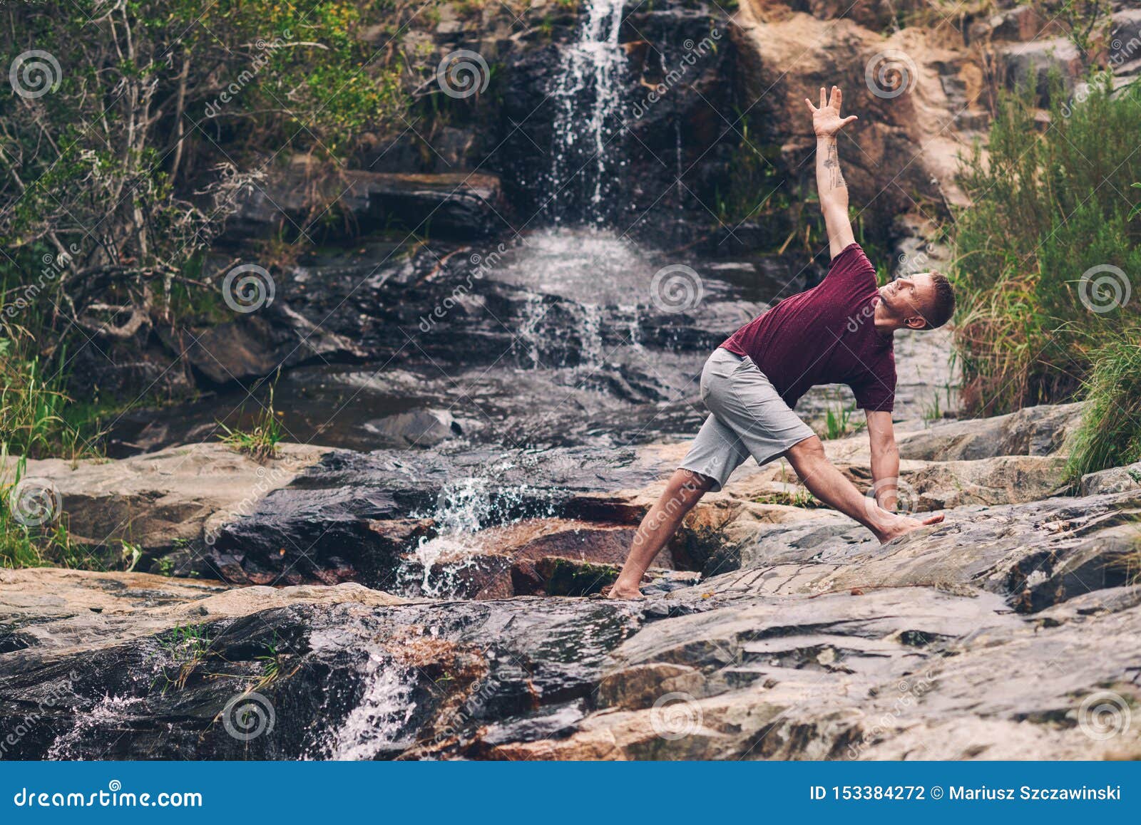 Fit Man Doing the Triangle Pose by a Waterfall Stock Photo - Image of ...
