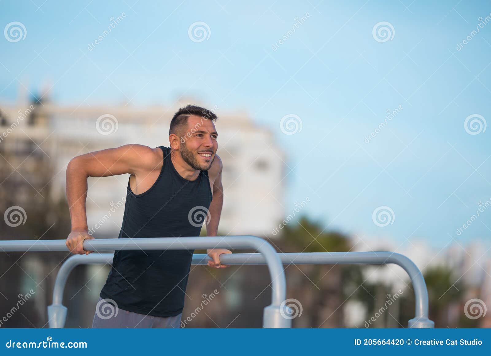 Fit Man Doing Triceps Dips on Parallel Bars Outdoors. Doing Exercises ...