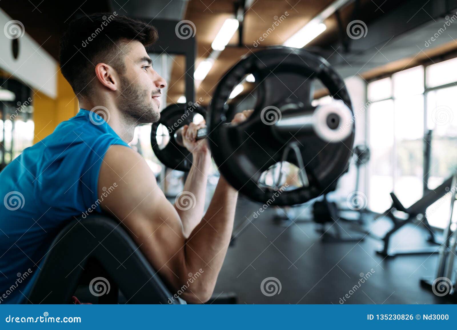 Fit Man Exercising at the Gym on a Machine Stock Photo - Image of ...