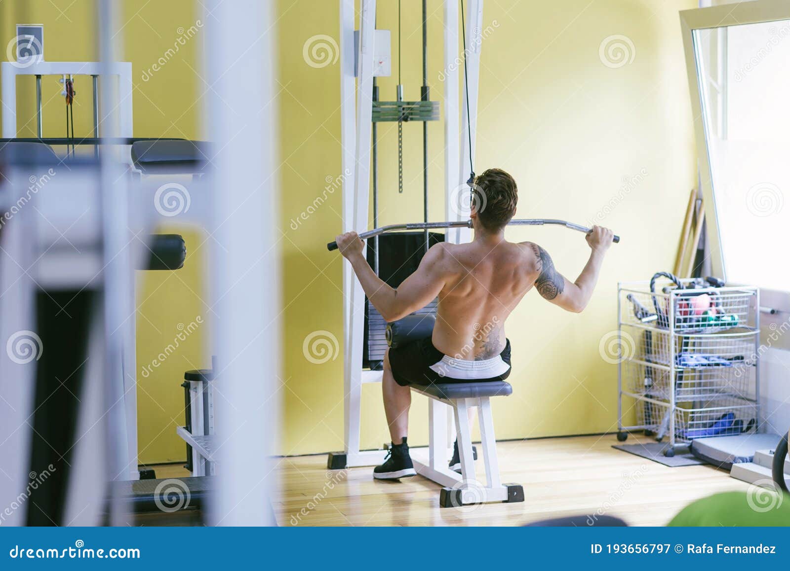 Fit Man on Lat Pull Down Machine at the Health Club. Work Out on Pull ...