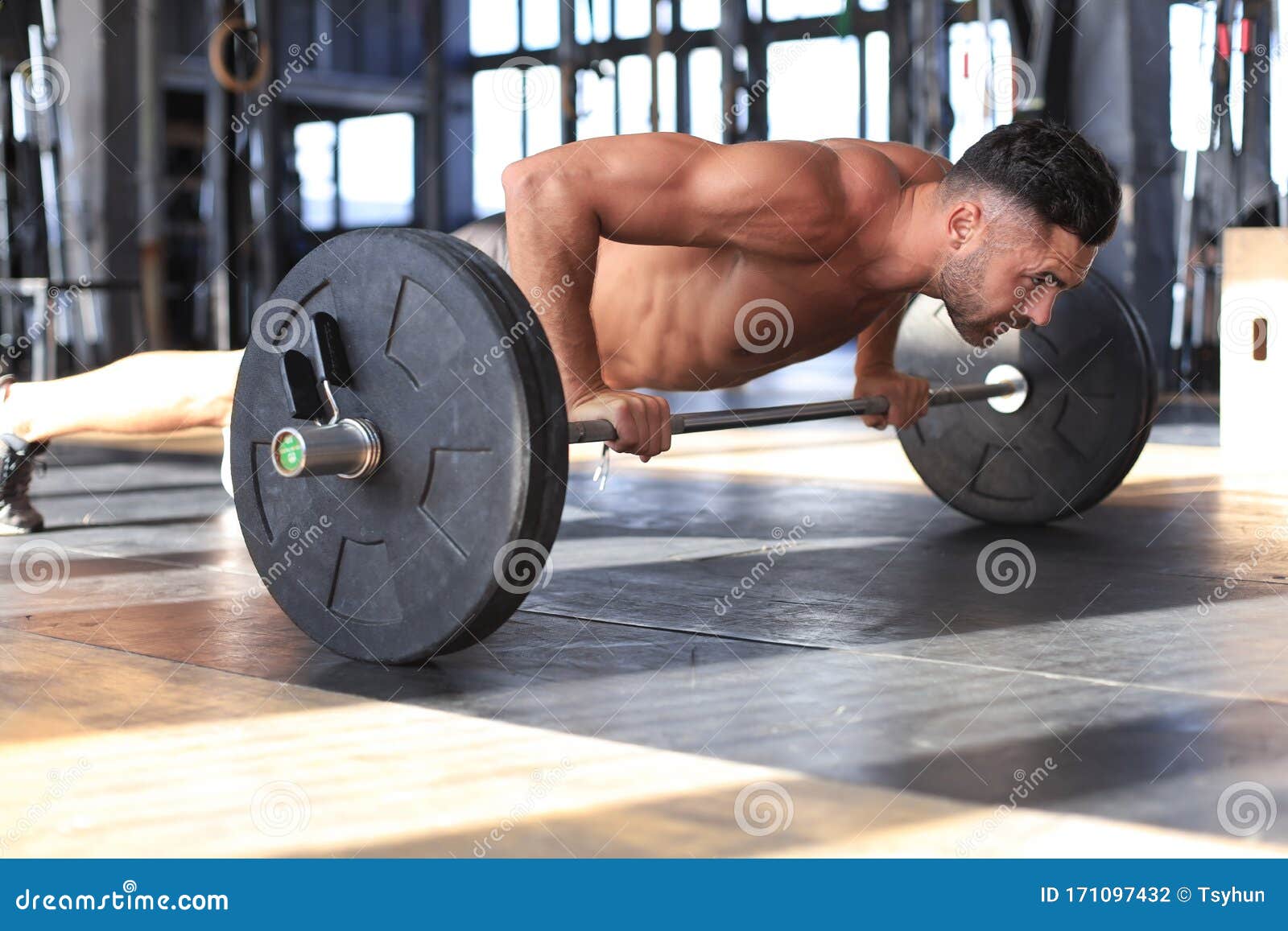 Fit and Muscular Man Doing Horizontal Push-ups with Barbell in Gym ...