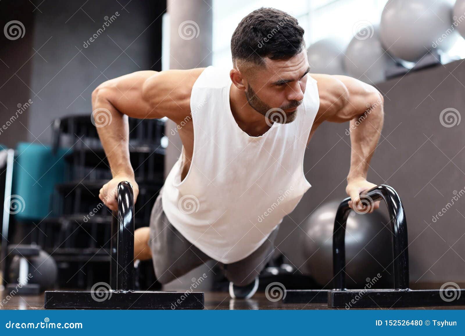 Fit and Muscular Man Doing Horizontal Push-ups with Bars in Gym Stock ...