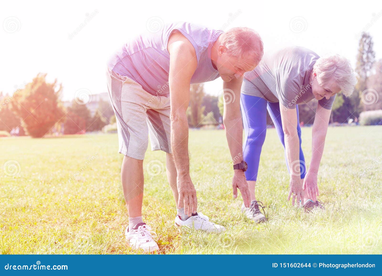 Fit Senior Couple Doing Toe Touching Exercise in Park Stock Photo ...