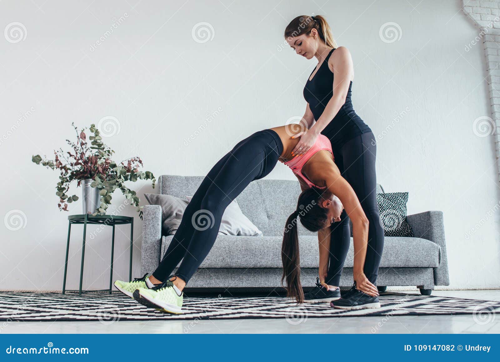 Fit Woman Making Arching Back with the Help of Personal Trainer ...