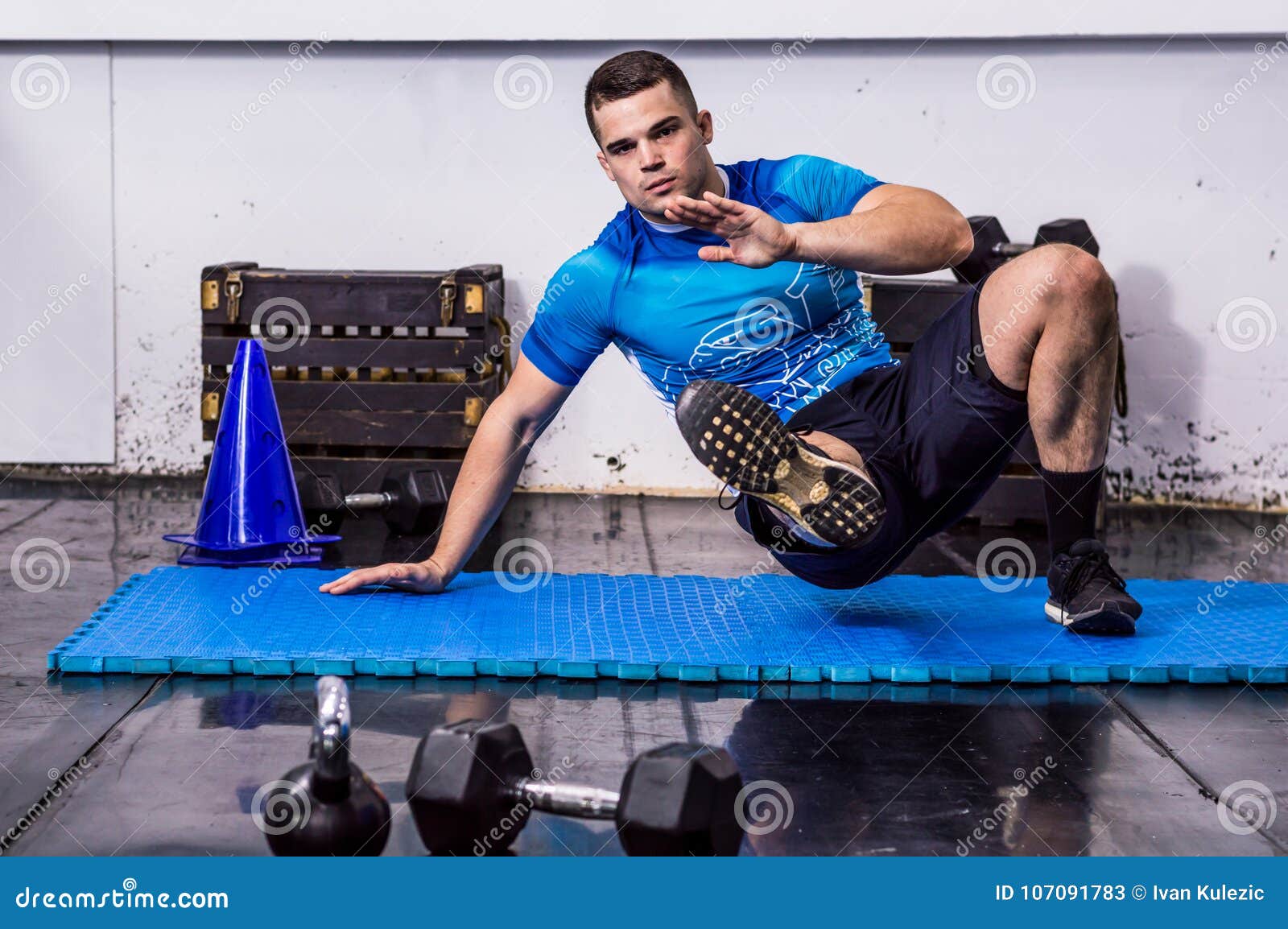 Fit Young Man Doing Leg Crossover Exercise at the Gym Stock Image ...
