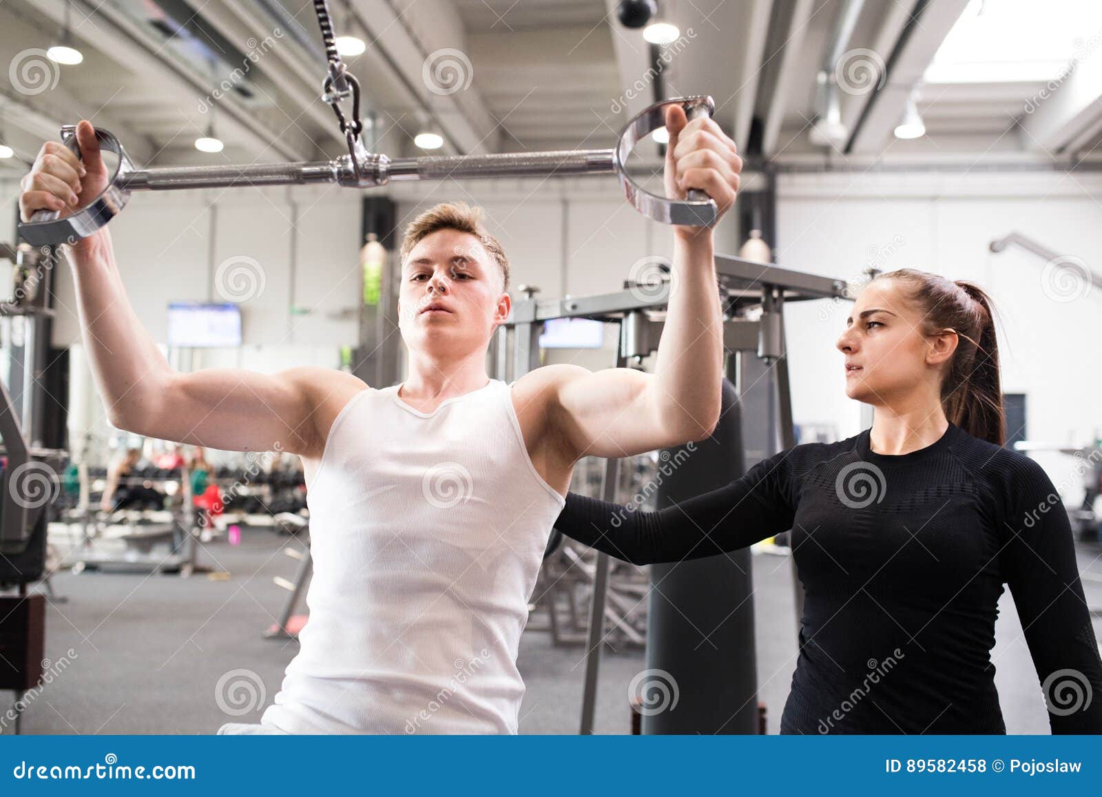 Fit Young Man in Gym Working Out on Pull-down Machine. Stock Photo ...