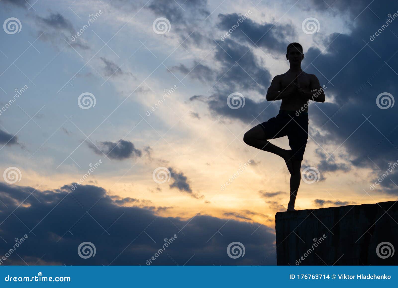 Fit Young Man Practices Sun Salutation Yoga on the Edge of Cliff at ...