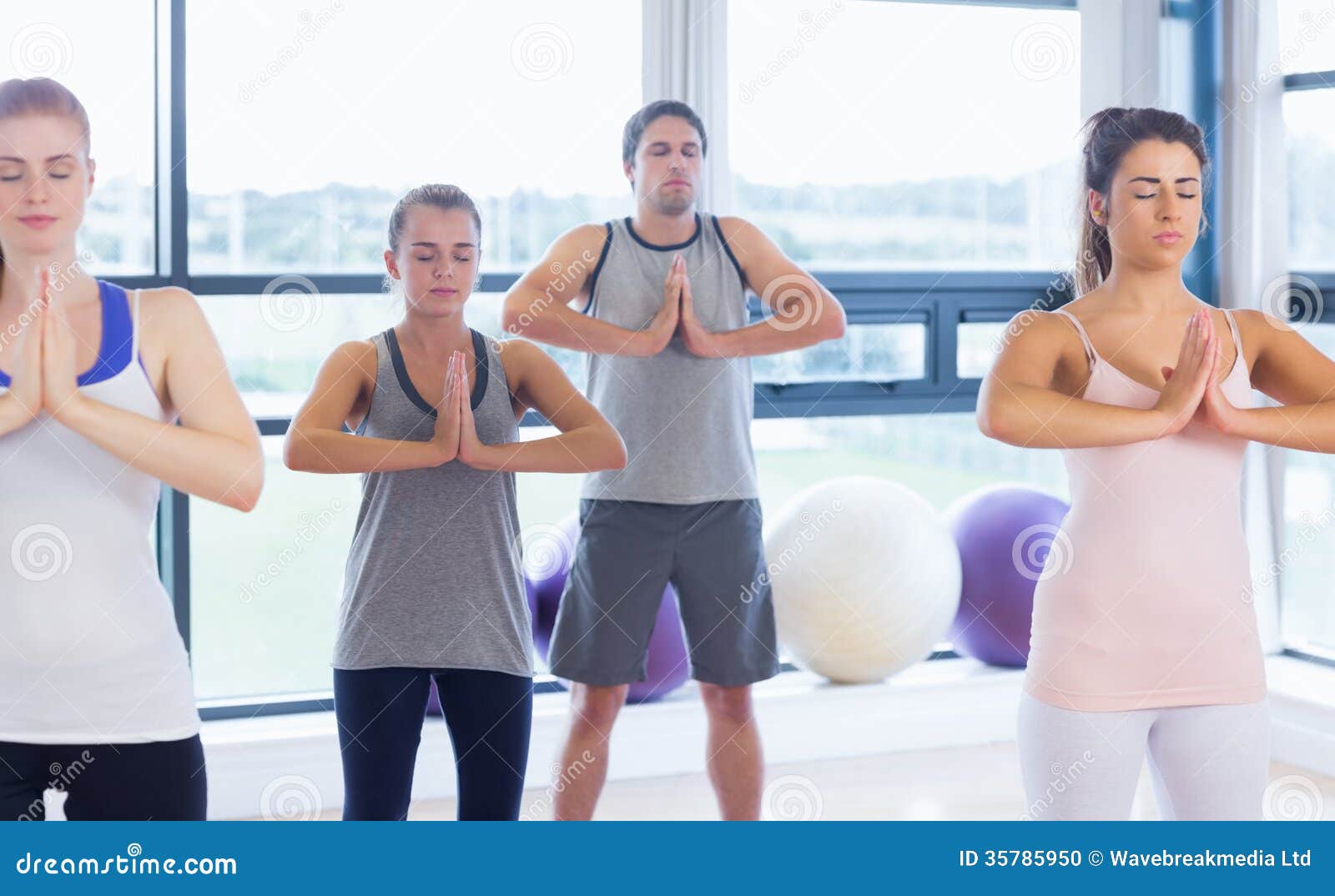 Fitness Class and Instructor Standing in Namaste Position Stock Photo ...