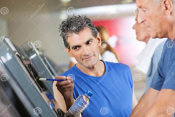 Fitness trainer explaining stock photo. Image of club - 23965816
