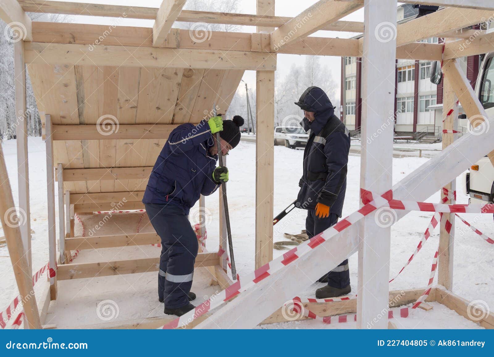 Fitter with a Metal Crowbar in Hand at the Construction of a Wooden ...