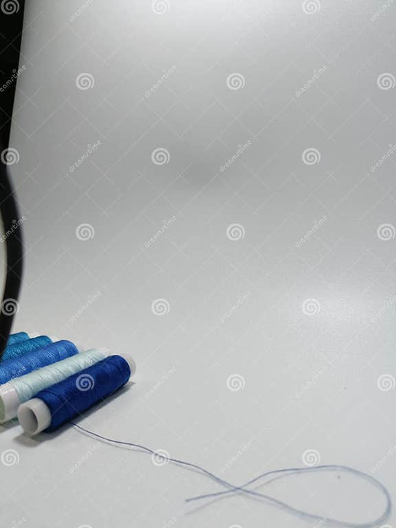 Blue Sewing Thread Spools with Unraveled Thread on White Background ...