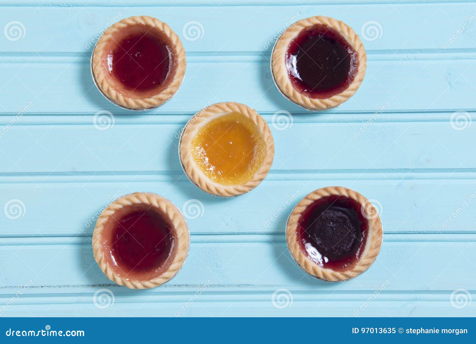 Five Colourful Jam Tarts on a Blue Background Stock Image - Image of ...