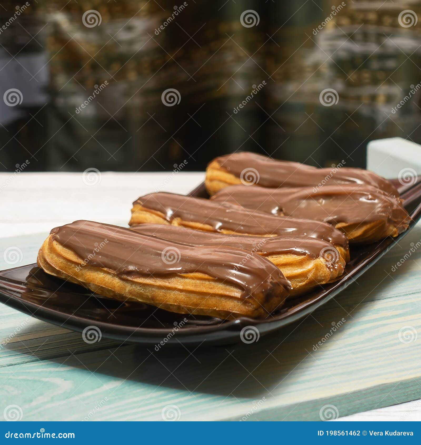 Five Fresh Eclairs Covered with Chocolate Glaze Lie on a Rectangular ...
