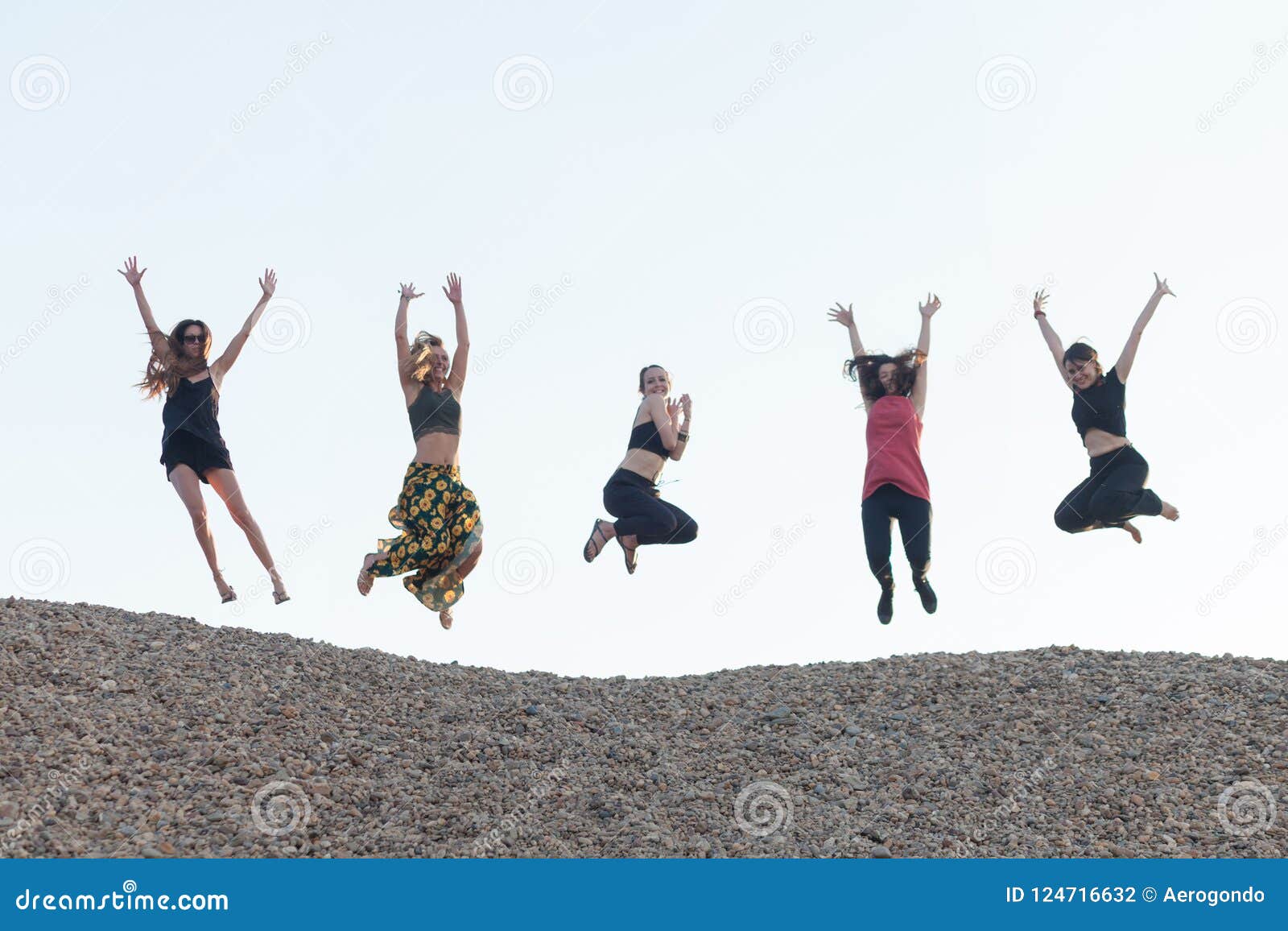 Five Girlfriends Jumping Together with Joy on Pebble Hill Stock Photo ...