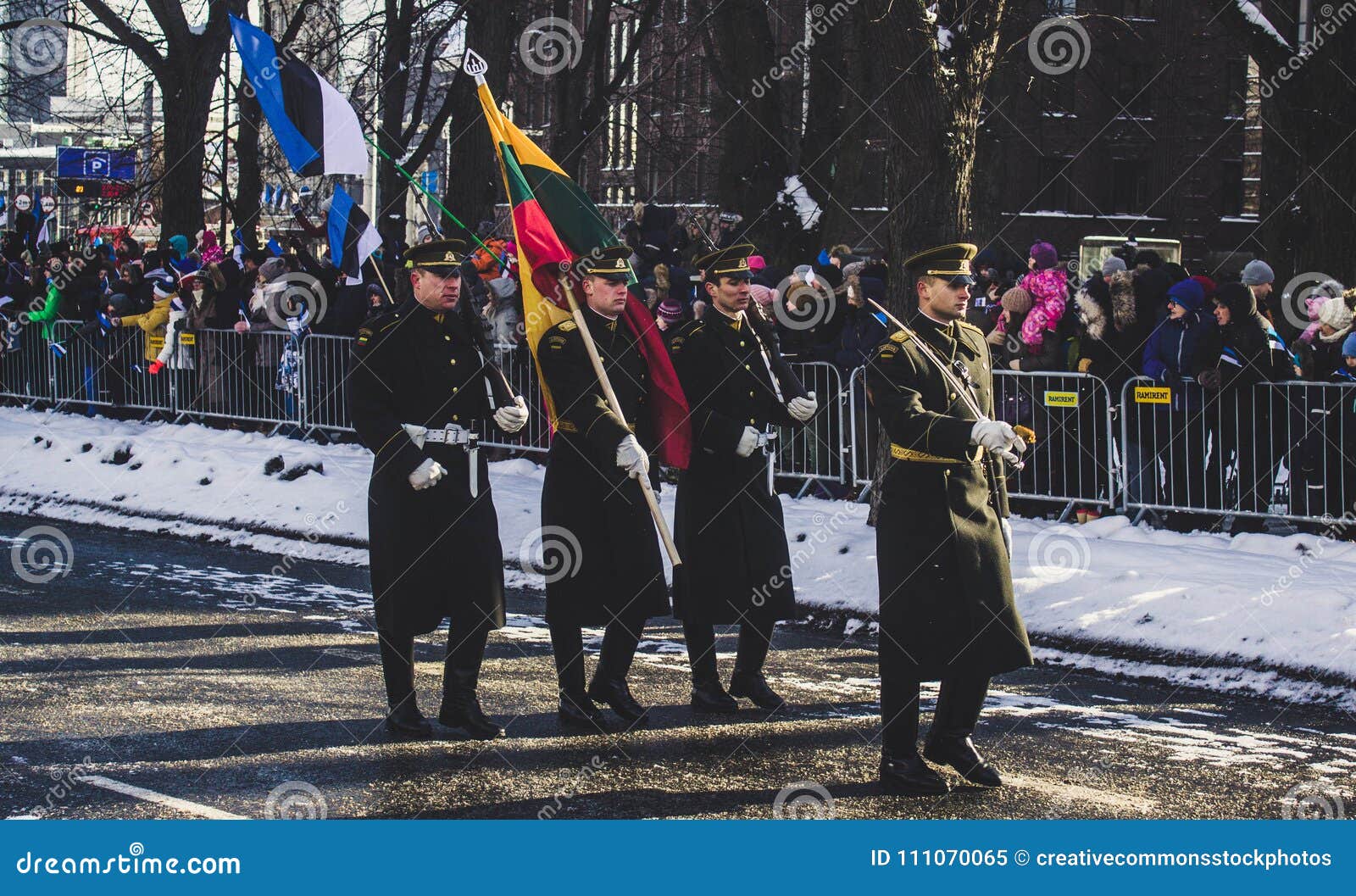 Five Men In Grey Suits Marching On Grey Pavement Near Crowd Of People ...