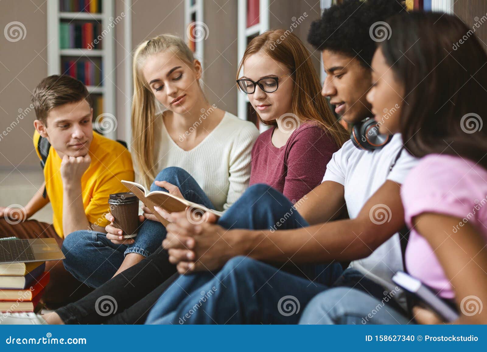 Five Classmates Reading Lecture Notes, Sitting on Library Floor Stock ...