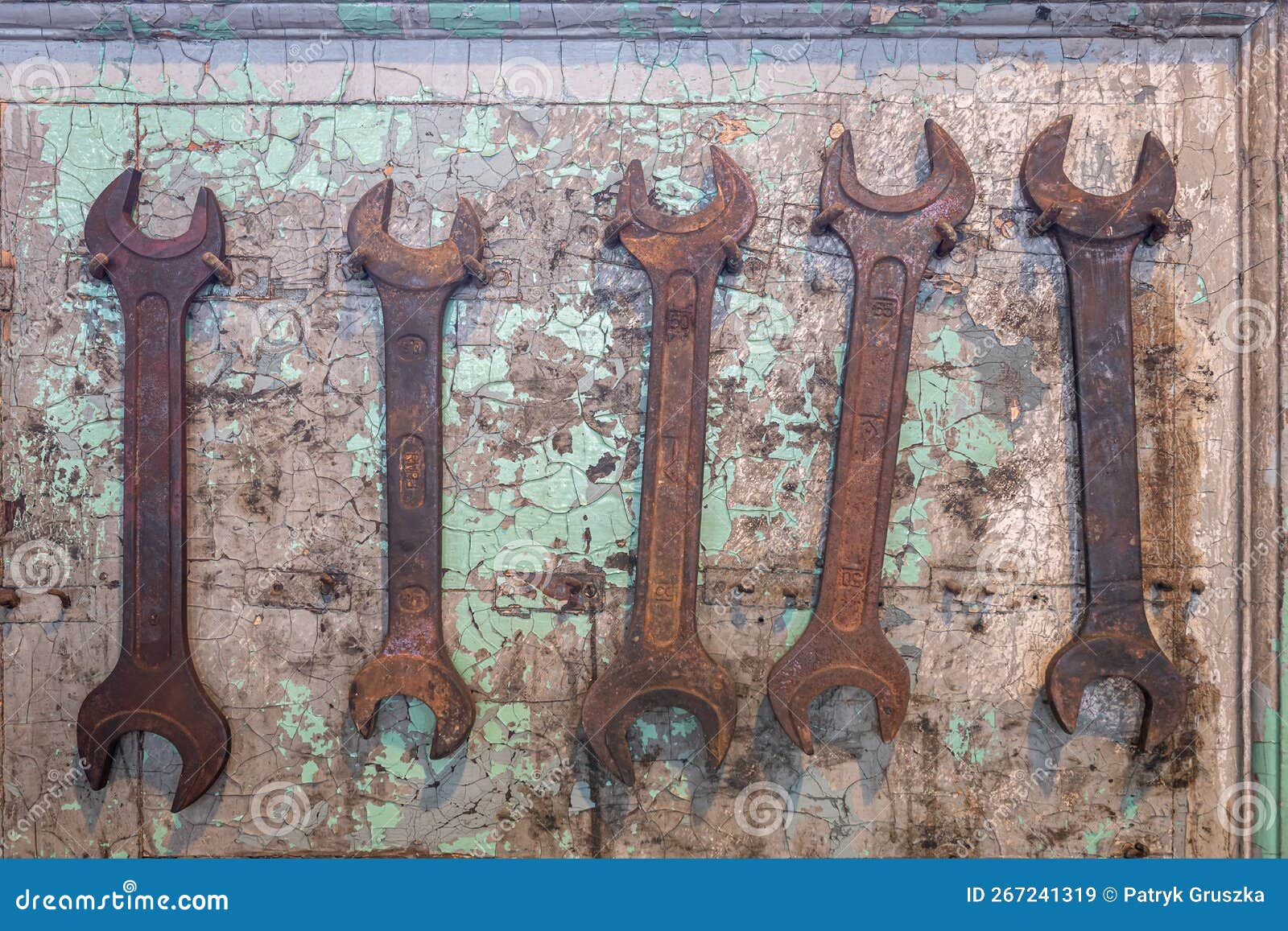 Five Old, Rusted Wrench Tools Hanging on Nails on Cracked, Damaged Wall ...