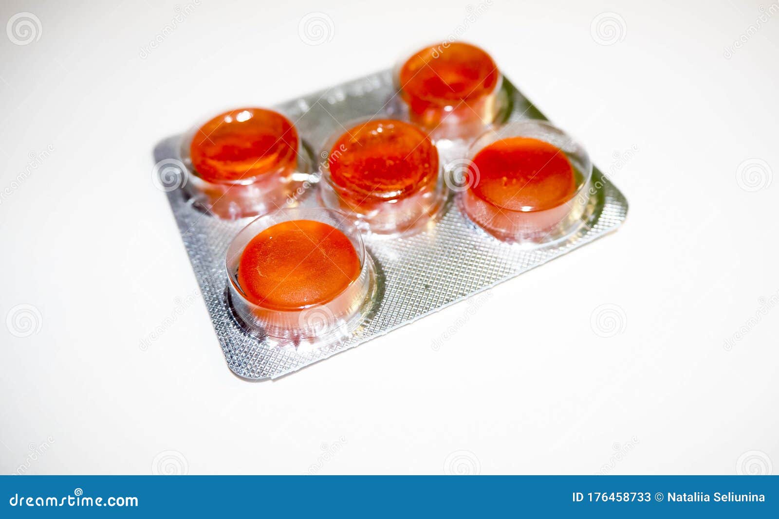 Five Red Round Jelly Tablets in a Gray Package on a Light Background ...
