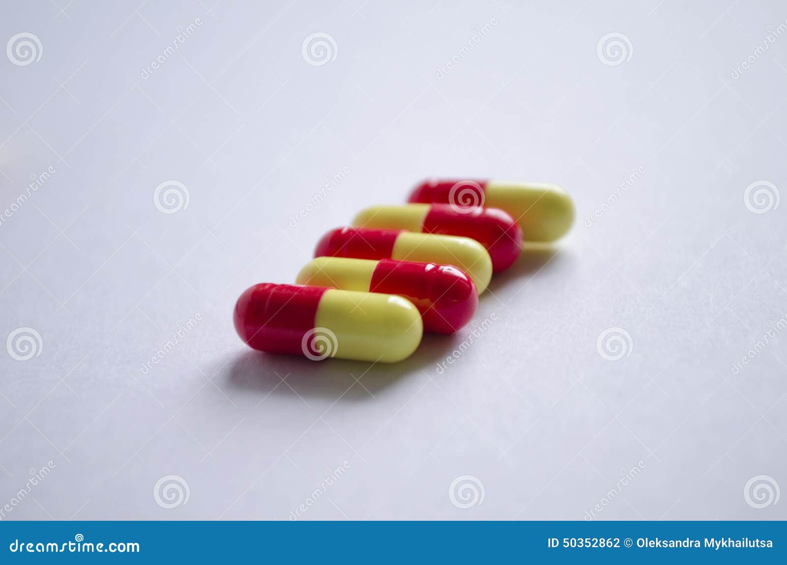 Five Red and Yellow Capsules on a Light Background Stock Photo - Image ...