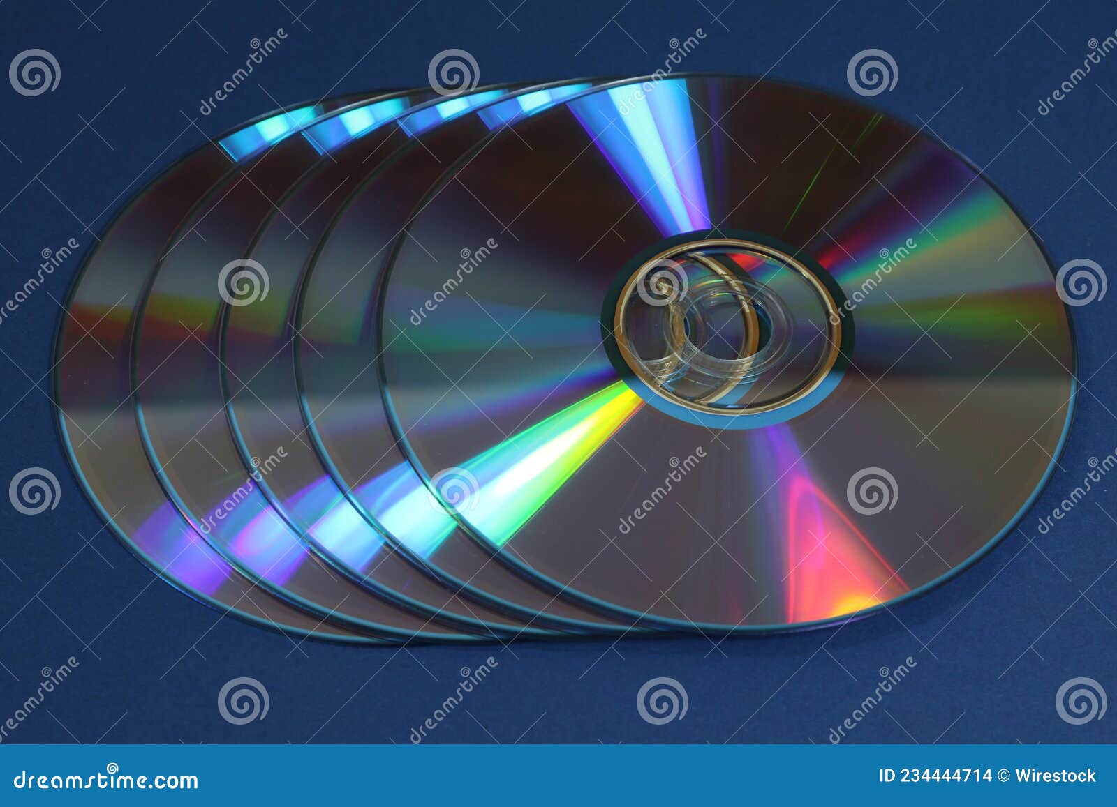 Five Shiny Compact CD and DVD Discs on the Dark Blue Surface Stock ...