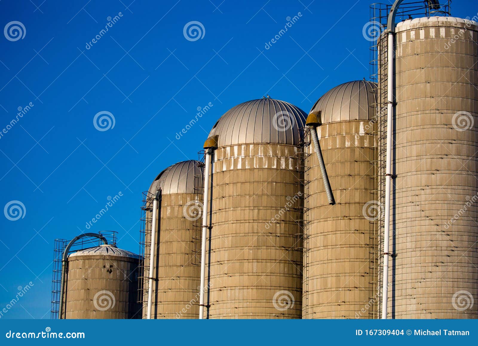 Five Silos at Different Hights in Front of a Blue Sky Stock Photo ...