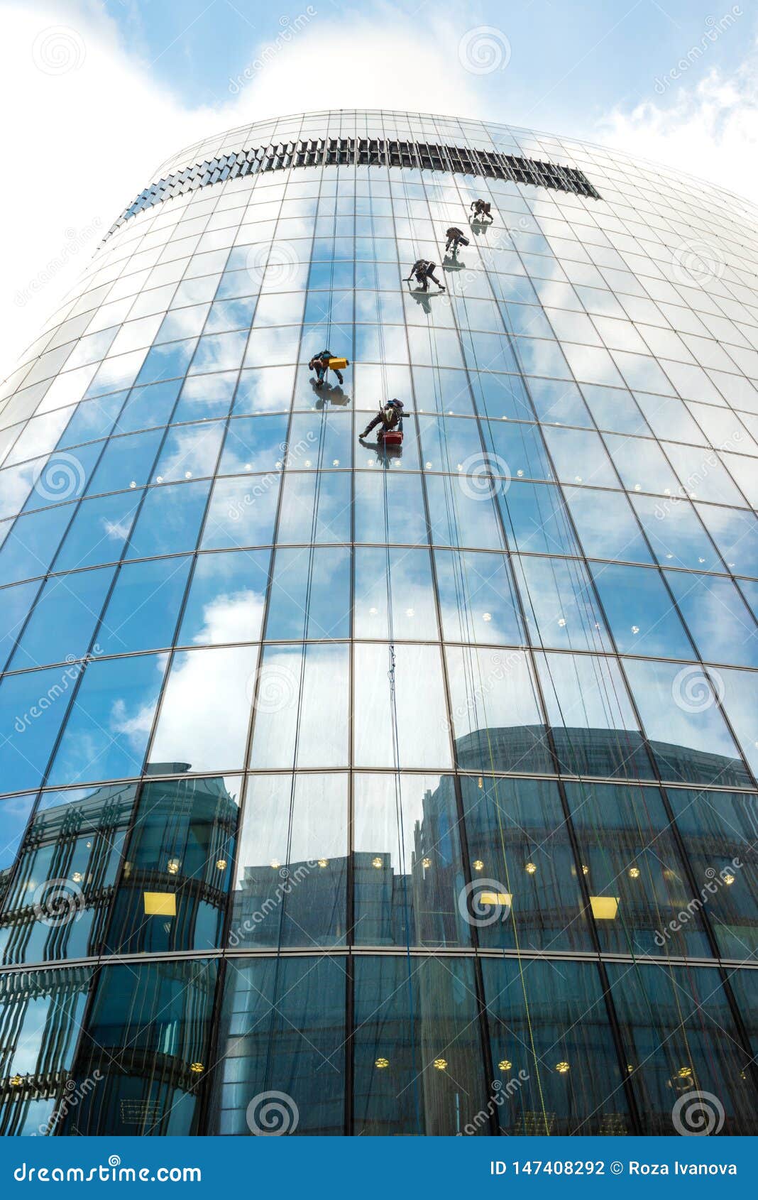 Five Window Washers Work at a Height on a High-rise Building with a ...