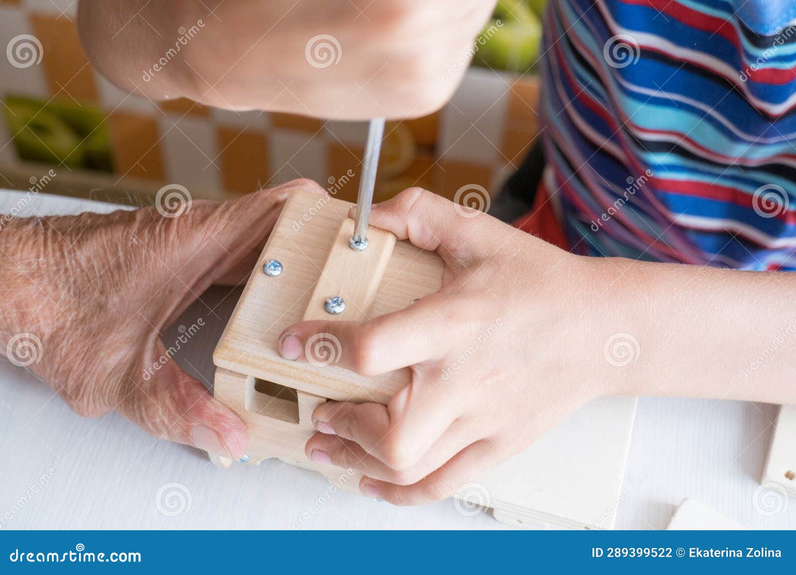 A Five-year-old Boy Independently Assembles a Wooden Construction Kit ...