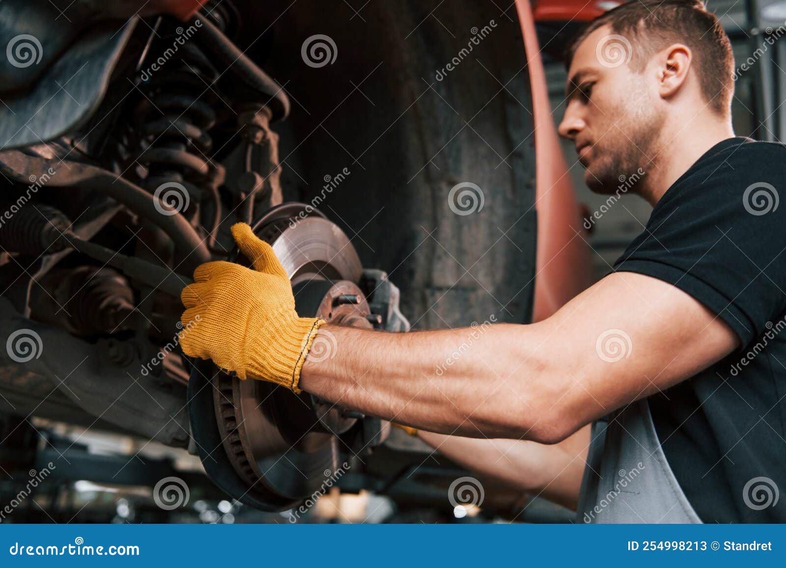 Fixing Breaks. Man in Uniform is Working in the Auto Service Stock ...
