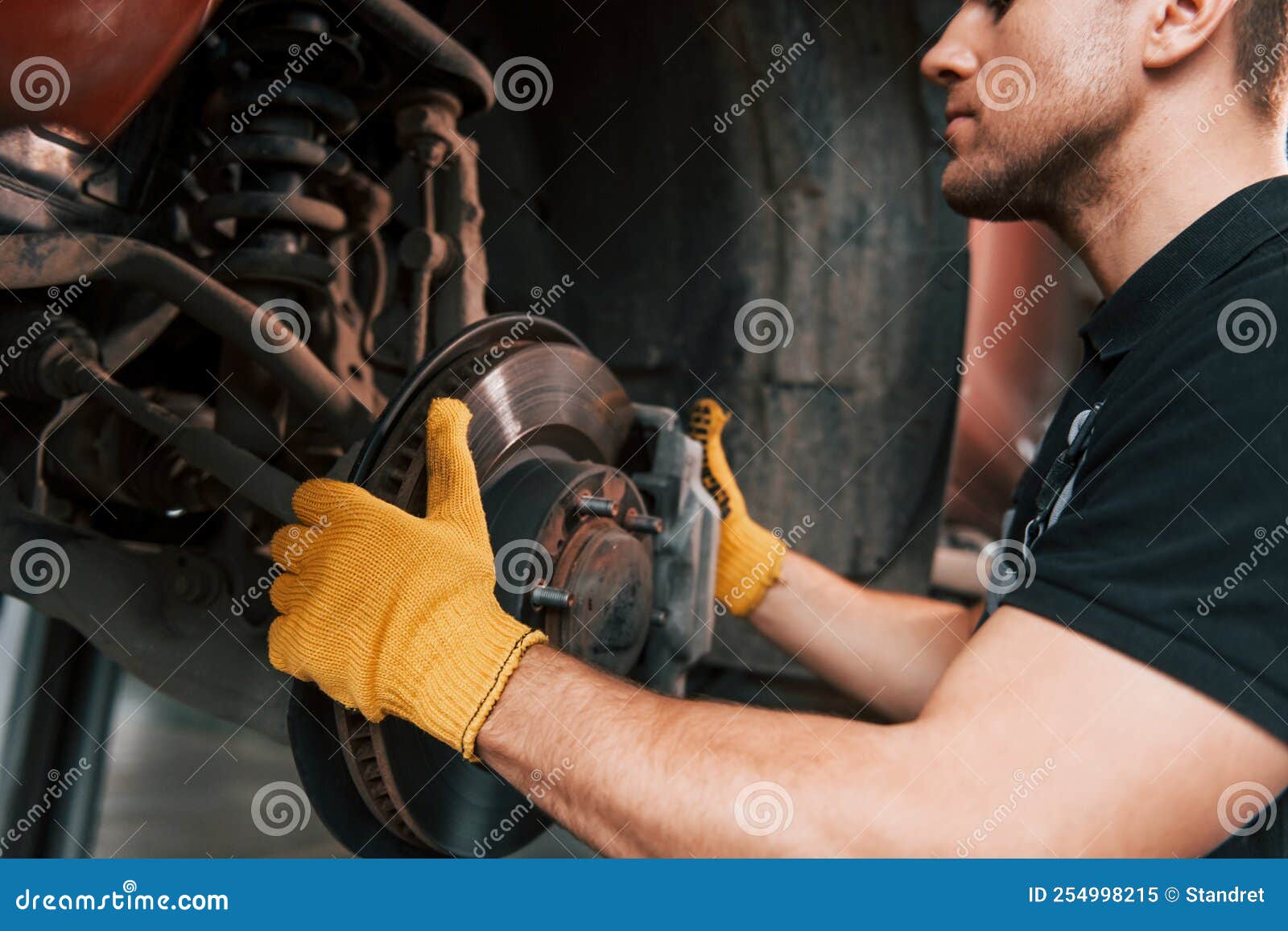 Fixing Breaks. Man in Uniform is Working in the Auto Service Stock ...