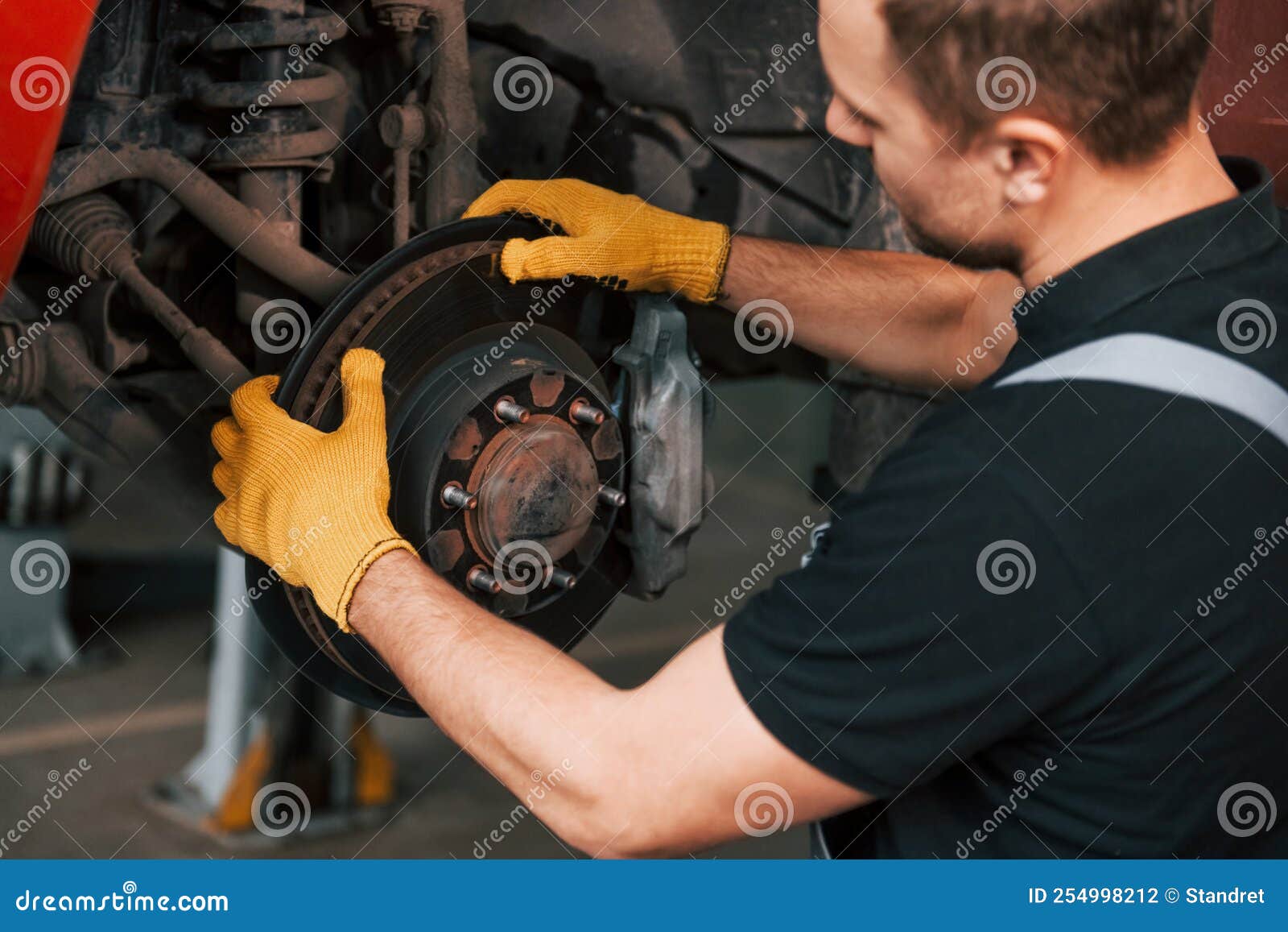 Fixing Breaks. Man in Uniform is Working in the Auto Service Stock ...