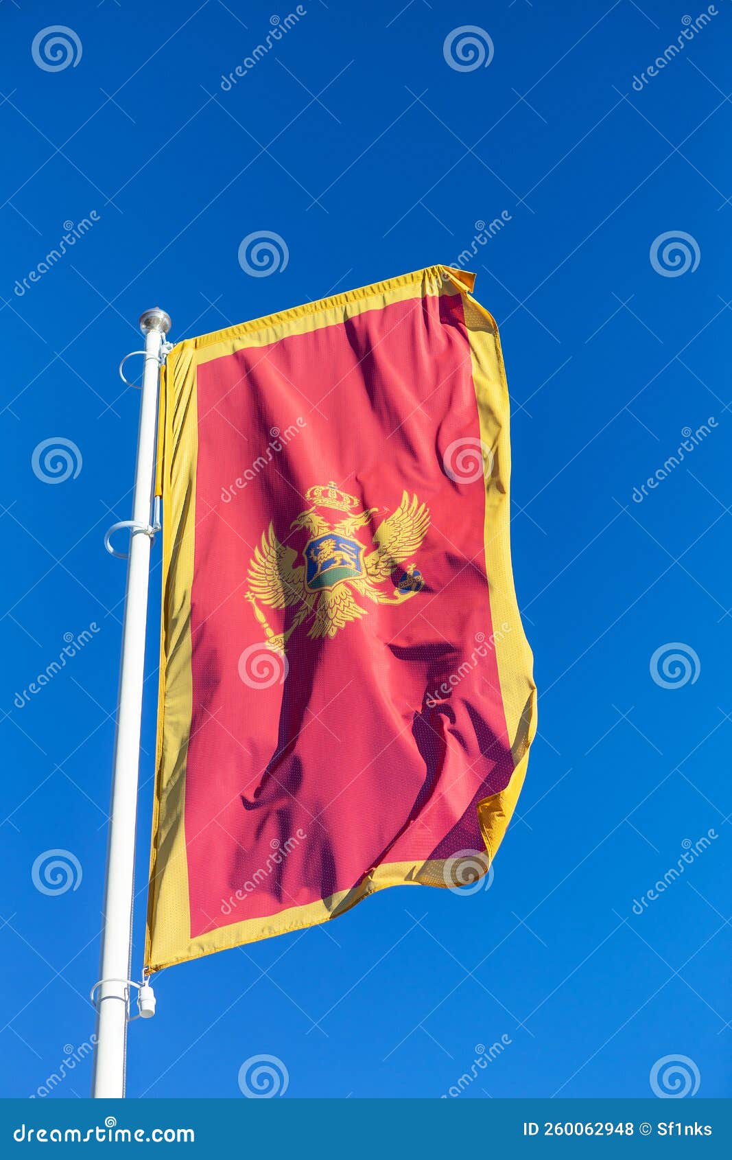 The Flag of Montenegro Develops in a Blue and Clear Sky. the National ...