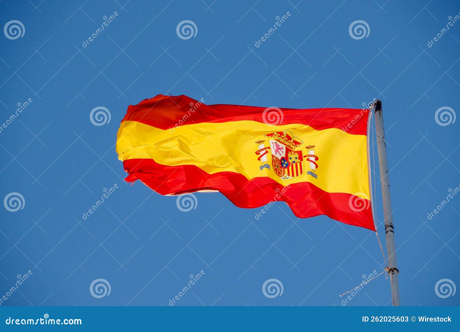 Flag of Spain Hung on a Pole in the Background of a Blue Sky. Stock ...