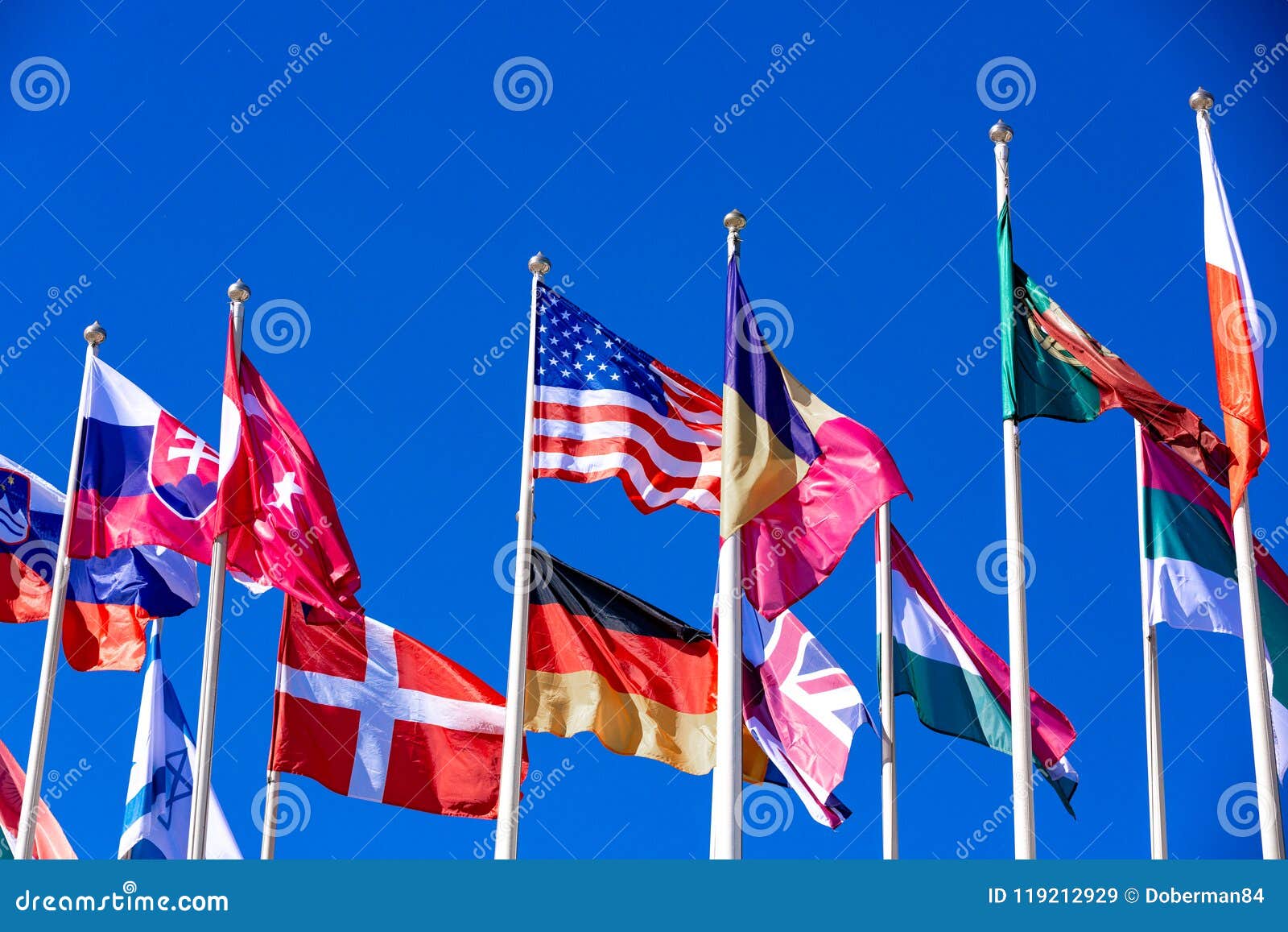 Flags of Different Countries Flutters in the Wind Against Stock Image ...