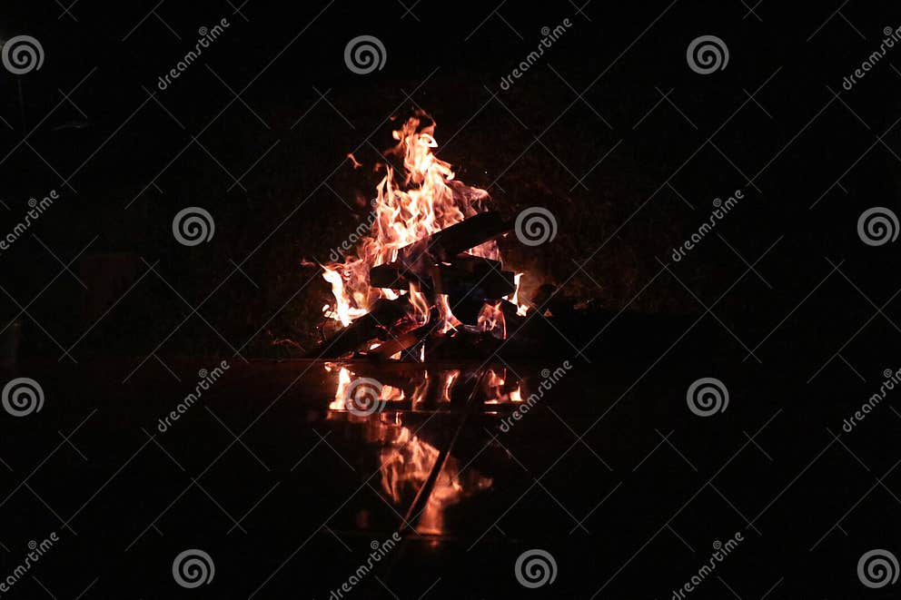 A Flaming Fire of Campfire in Dark with Reflection on it. Stock Image ...