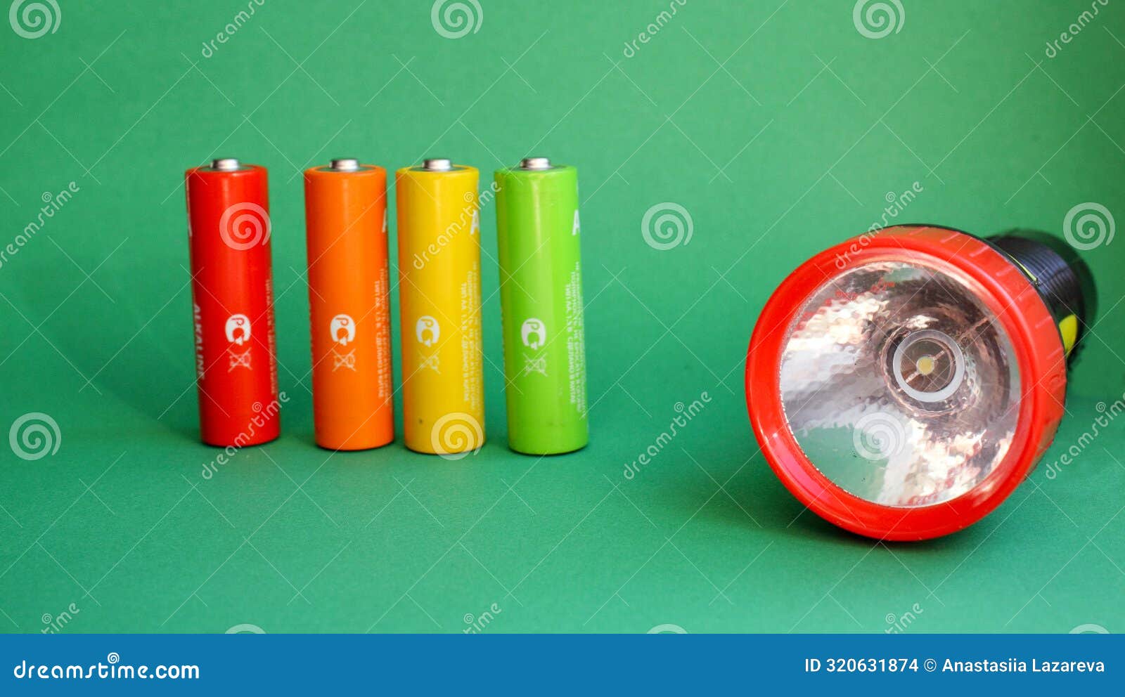 Flashlight and Four AA Batteries on a Green Background. Illumination ...