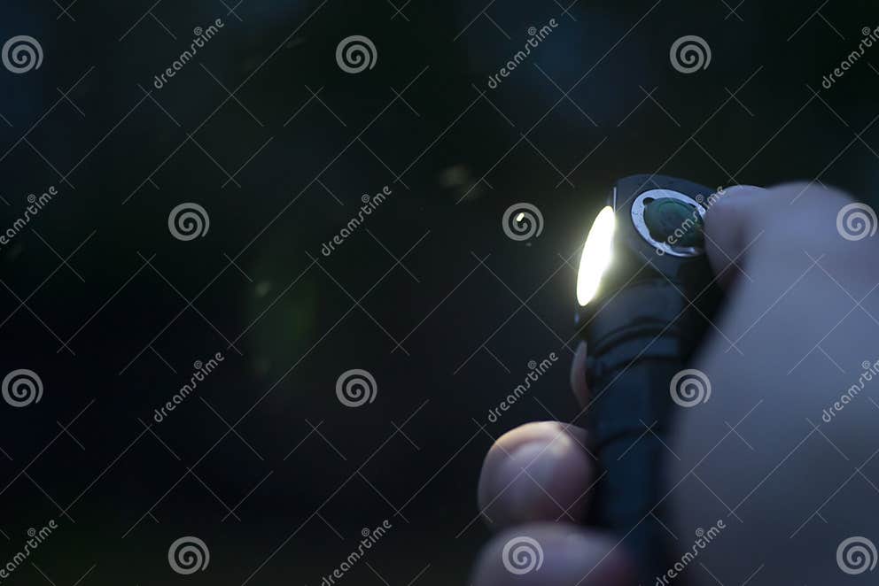 A Flashlight Shines in the Rain during a Hike. Raindrops Fly through ...