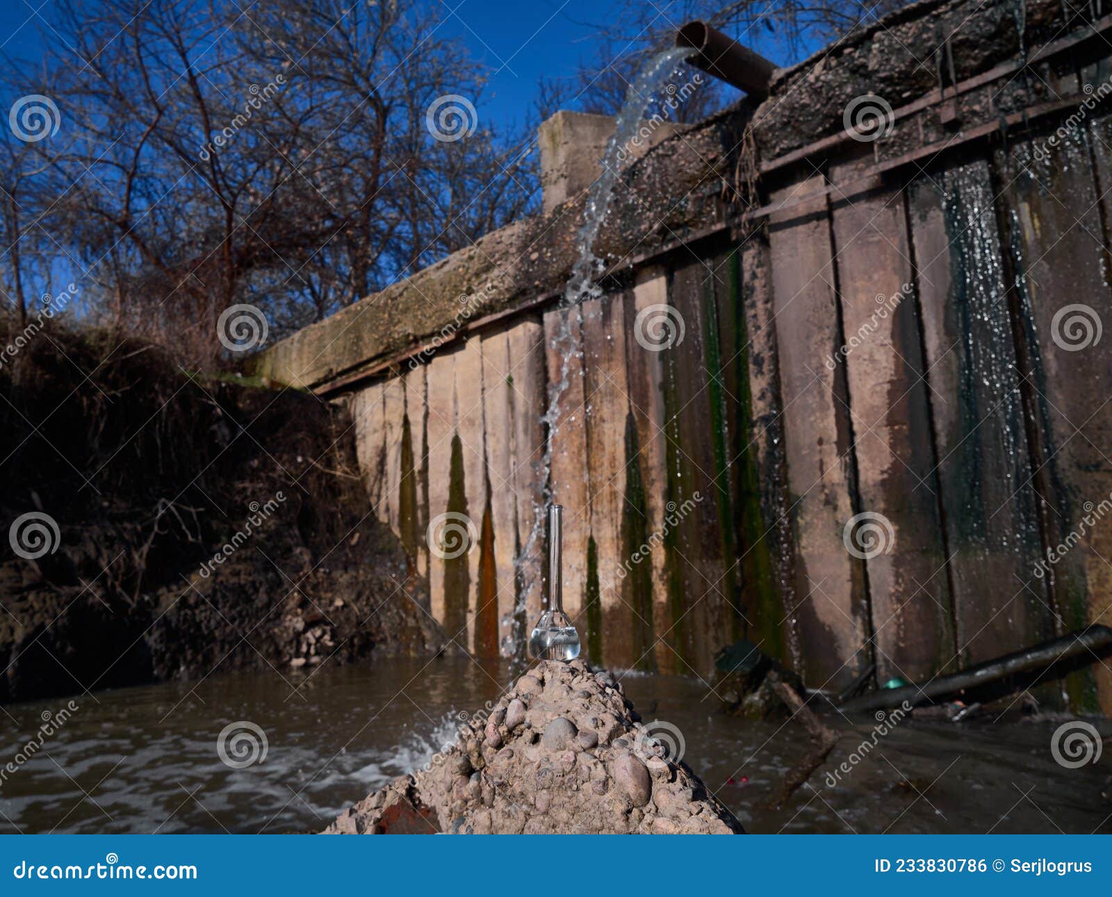 Flask with Clean Drinking Water Against the Background of Sewage ...