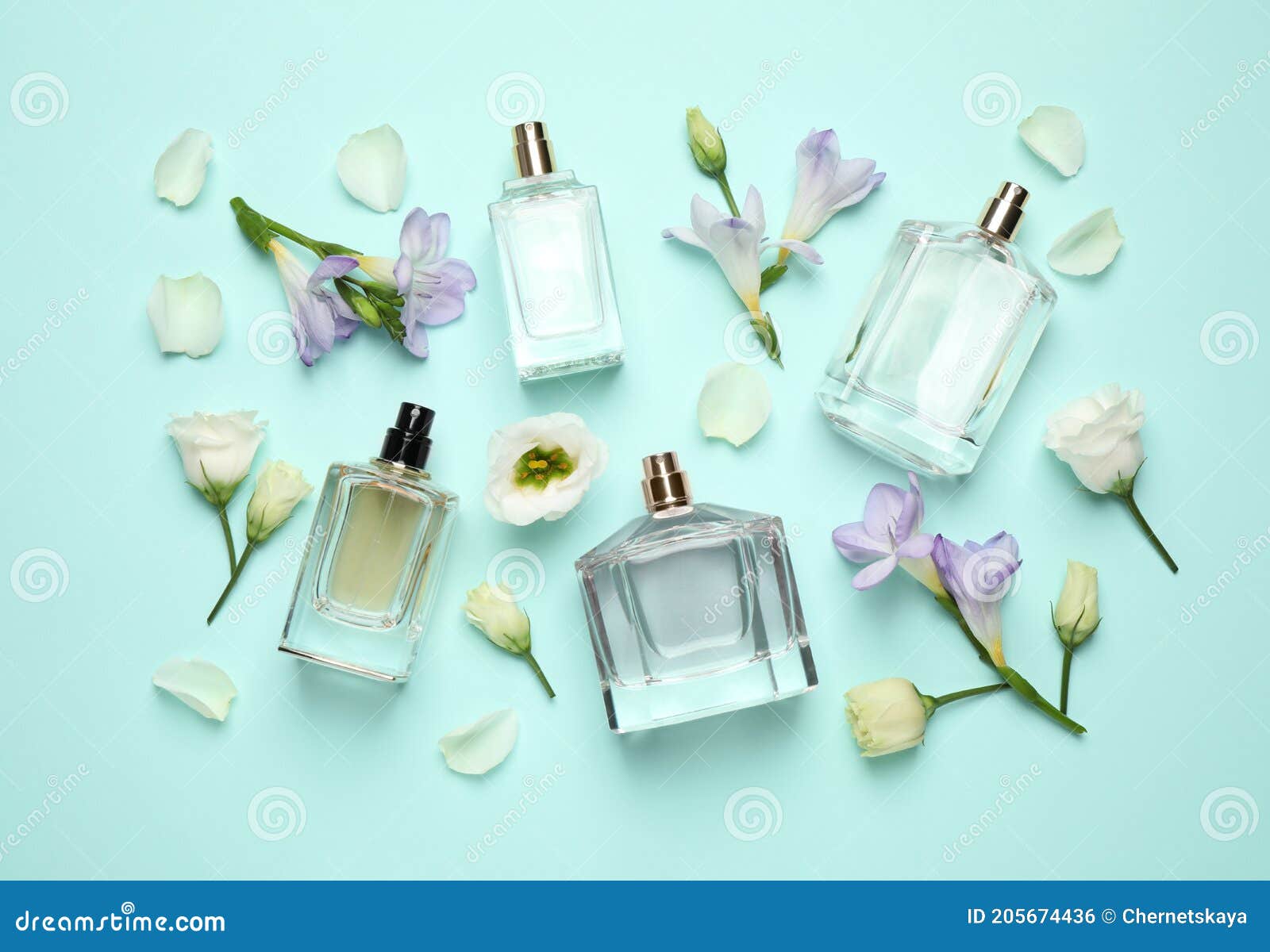 Flat Lay Composition with Different Perfume Bottles and Flowers on Cyan ...