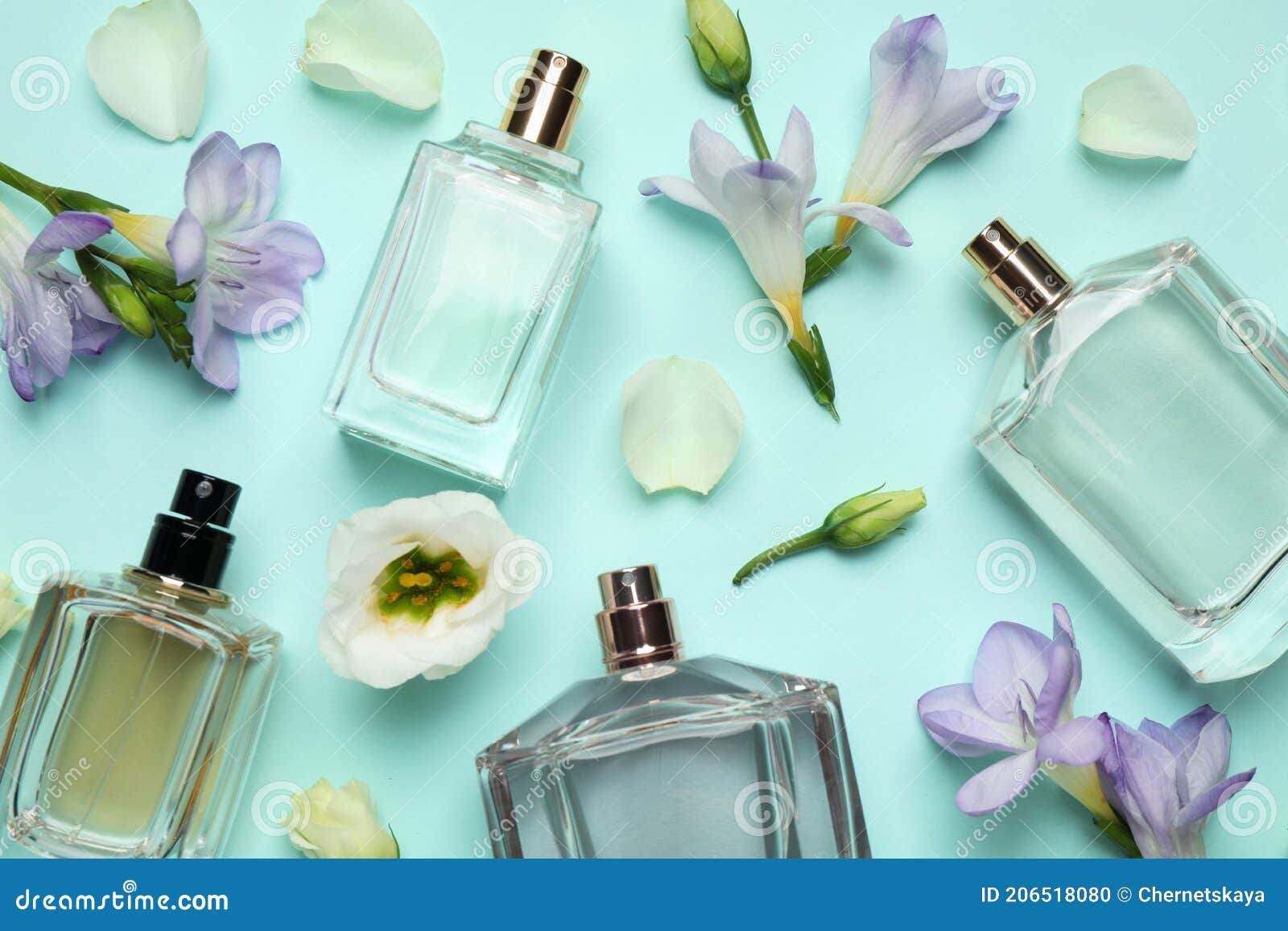 Flat Lay Composition of Different Perfume Bottles and Flowers on Cyan ...