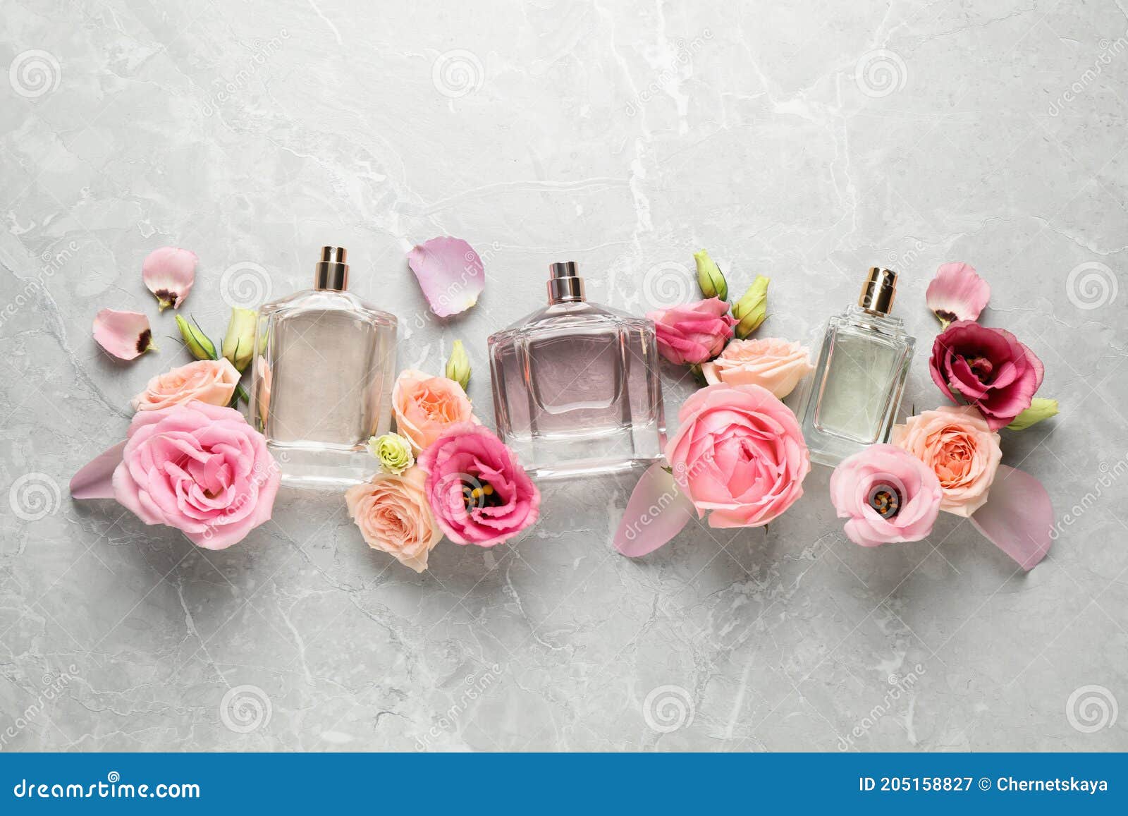 Flat Lay Composition of Different Perfume Bottles and Flowers on Light ...