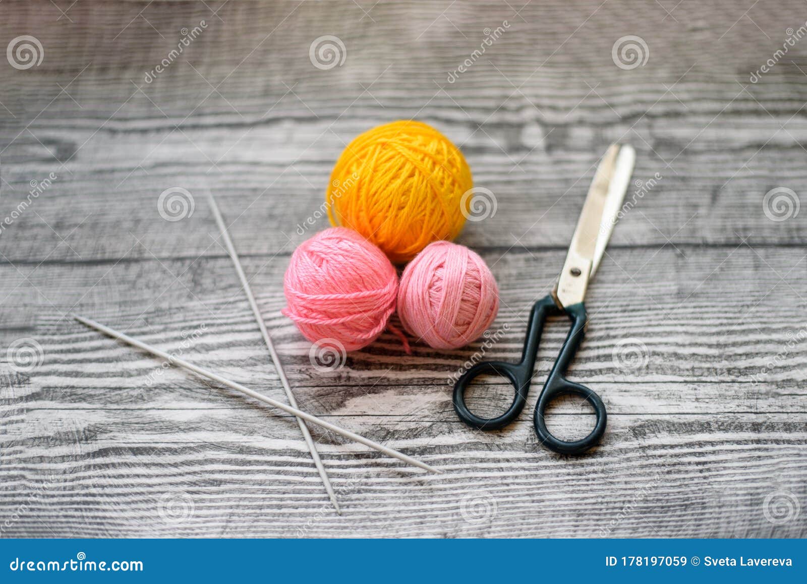 Three Colored Wool Balls, Knitting Needles And Scissors On The Wooden ...