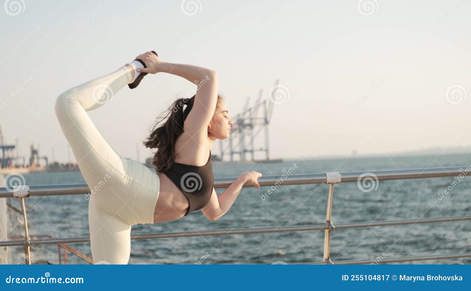 Flexible Female Gymnast Doing Acrobatic Tricks at Sunrise on the Beach ...