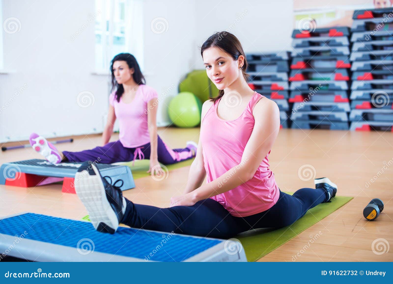 Flexible Fit Women Stretching Legs with Aerobic Step Platforms. Stock ...