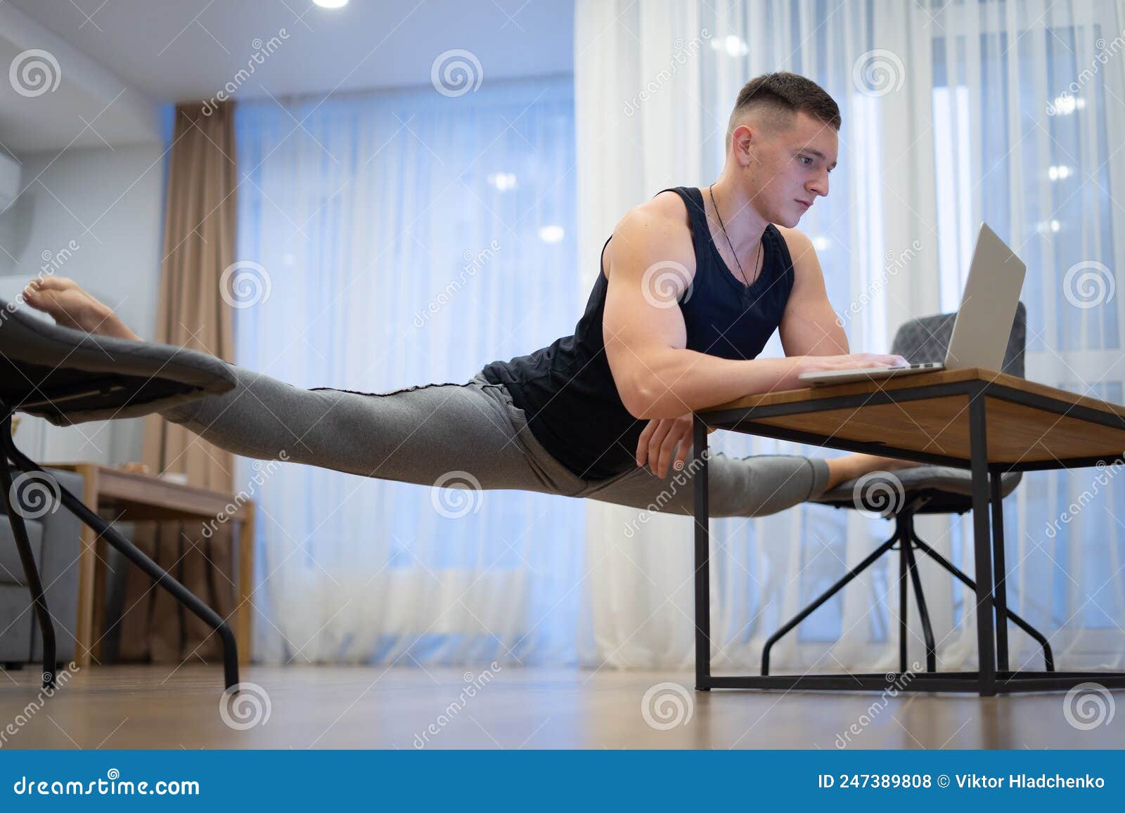 Flexible Man Work on Laptop and Doing Leg-split at Home. Concept of ...