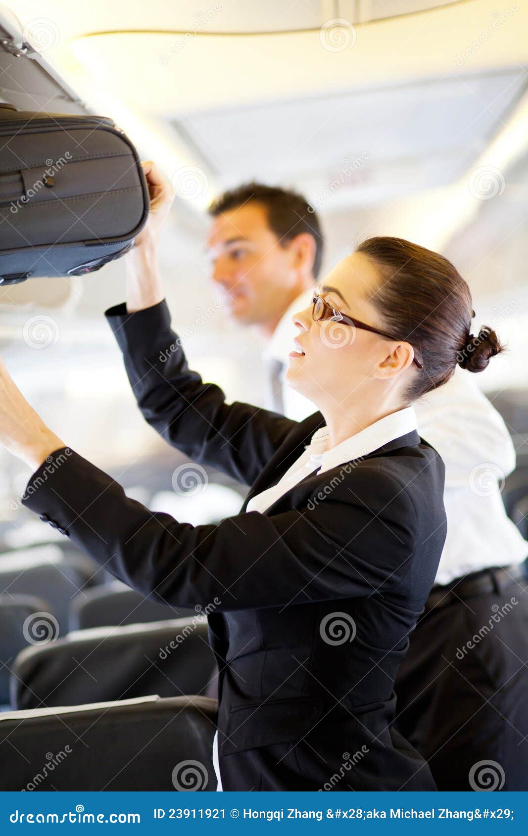 Flight Attendant Helping Passenger Stock Image - Image of baggage ...