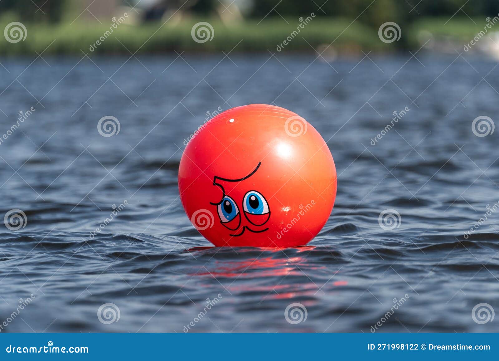 Floating Red Bal with a Face Floating Upside Down on the Water Stock ...