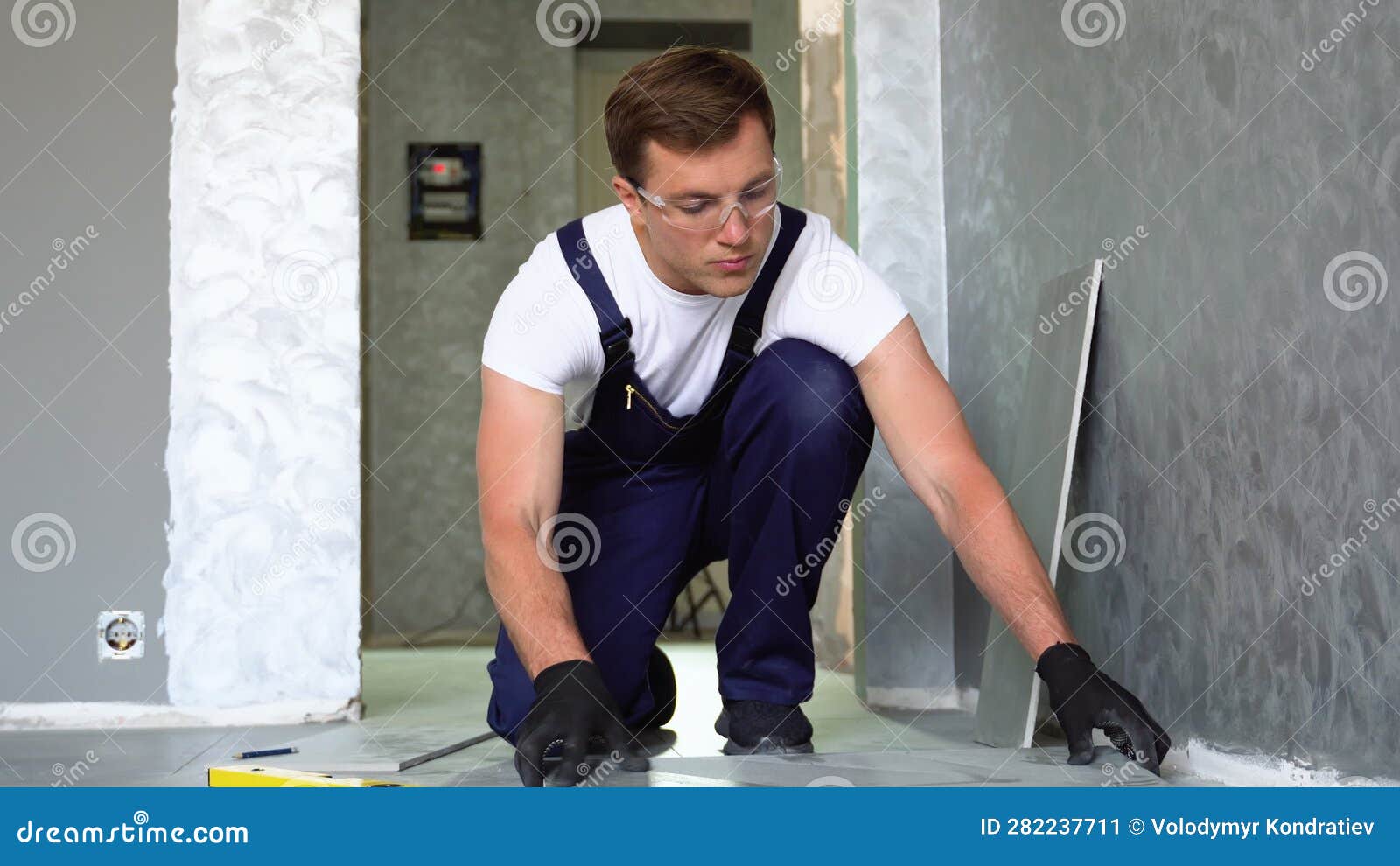 Flooring and Tiling. Professional Tiler Placing Floor Tiles on Adhesive ...